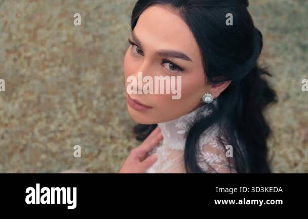 A high-angle medium close-up. A person in a white Javanese kebaya ...