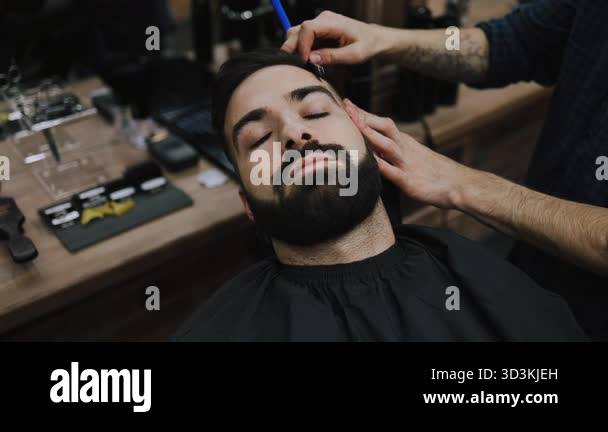 Professional barber precisely trimming a man's haircut with straight ...