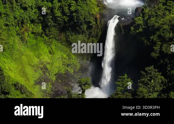 Rapid cascade surrounded by lush foliage. Limunsudan Falls. Mindanao ...