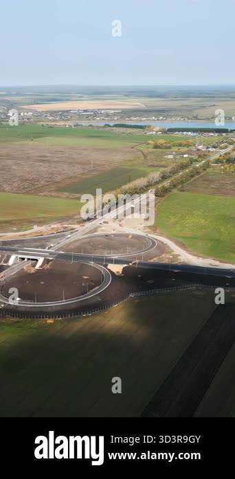 Cars driving on newly built roundabout interchange connecting roads in ...