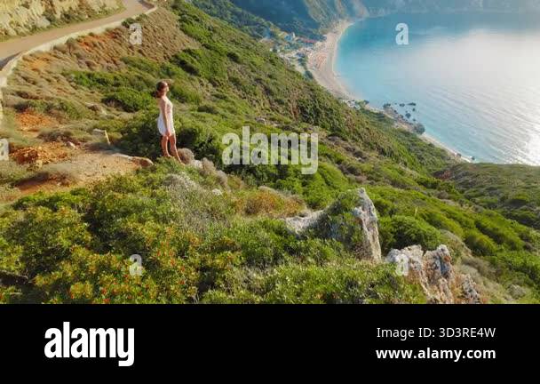 Woman in dress overlooking Petani Beach from a hilltop on Kefalonia in ...