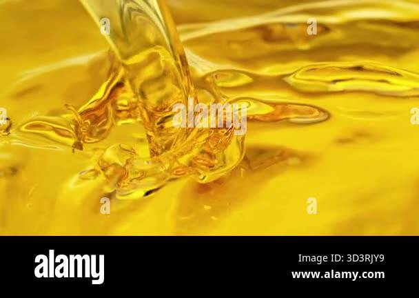 Super Slow Motion Shot of Pouring and Splashing Golden Oil Liquid at ...