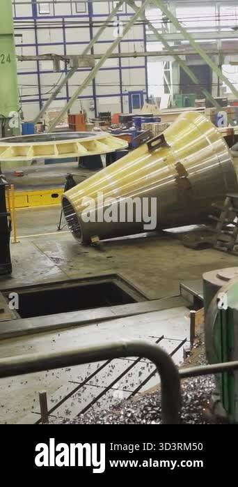 Skilled factory worker operating a cnc machine, producing metal parts ...