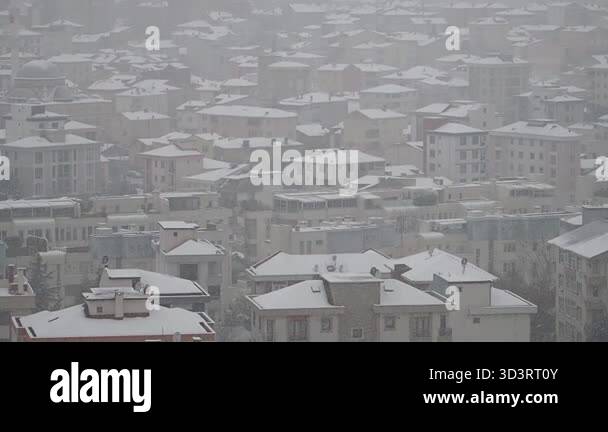 Snow covers houses in a quiet city, creating a serene winter landscape ...