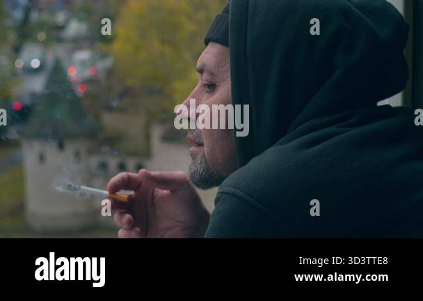 Sad man smokes on the balcony. Emotional portrait of handsome man sad ...