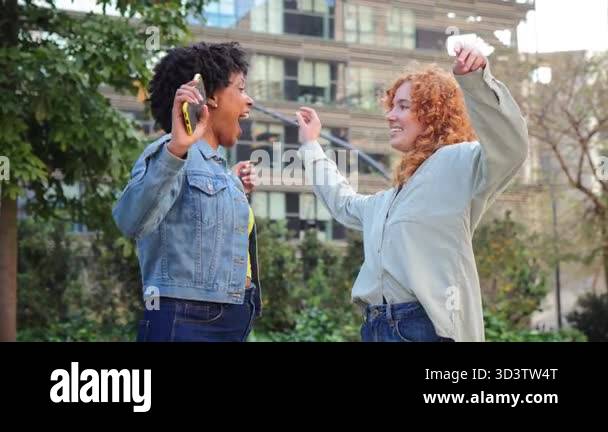 Two happy girls dancing and enjoying their favorite music together ...