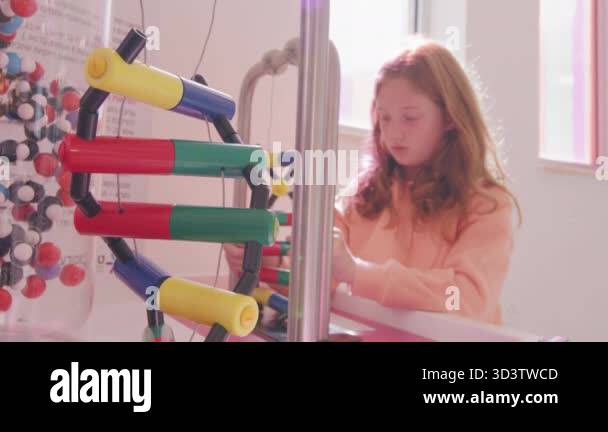 Cute school teenage girl is studying structure of DNA in the modern ...