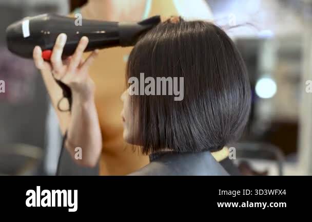 woman getting her short hair cut and styled at a beauty salon ...