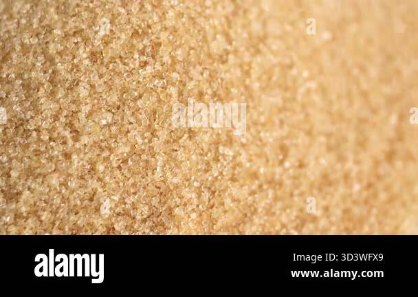 granulated brown sugar pouring onto pile, sugar crystals, food material ...