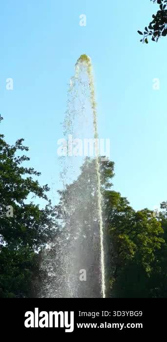 Water shoots into the air from a tall fountain creating a shimmering ...