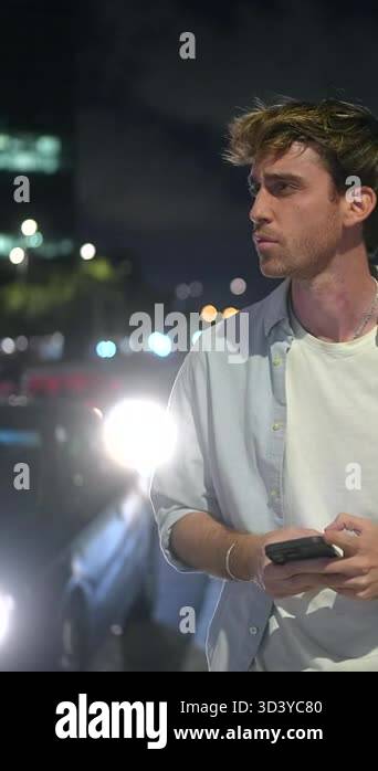 Serious young caucasian man waiting for someone on a city street at ...