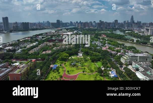 An aerial view shows a green park and river in front of the modern ...