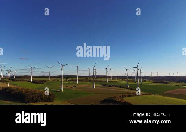 Wind turbines rotate gently in the breeze showcasing renewable energy ...