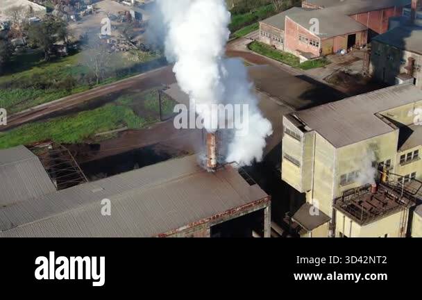 Orbiting Aerial View of Industrial Factory Complex with Smoke Billowing ...