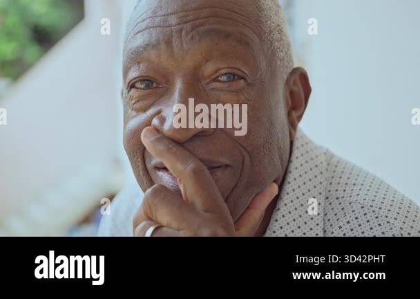 Elderly Man In Close-Up Portrait With Hand On Chin Looking Into Camera ...