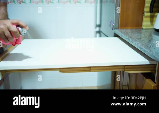 A person demonstrates the process of cleaning a white kitchen ...