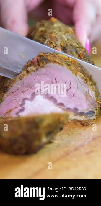 Chef slicing freshly grilled juicy beef steak meat with a knife on a ...
