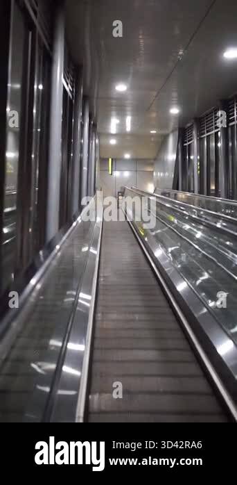 Modern escalator walkway inside a public building, featuring clean ...