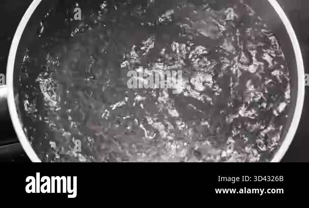 boiling water texture closeup on electric stove, food closeup top view ...
