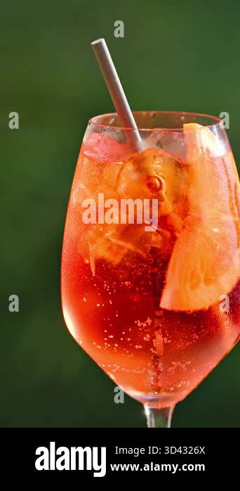 glass of fresh refreshing aperol spritz cocktail against a green ...