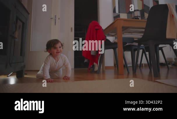 Smiling toddler crawling on floor after losing balance, showing ...