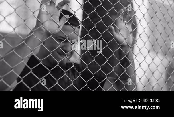 Latin Hispanic man of African descent striking fence in anger and ...