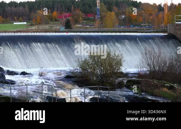 Artificial fish ladder in a river with water flowing over concrete ...