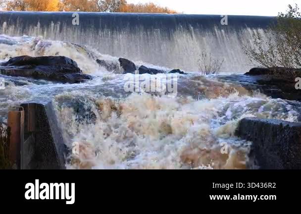 Artificial fish ladder in a river with water flowing over concrete ...