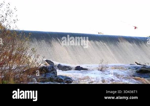 Artificial fish ladder in a river with water flowing over concrete ...