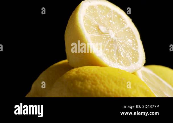 Lemons Macro Detail. A stack of lemons with a cut half on top rotates ...