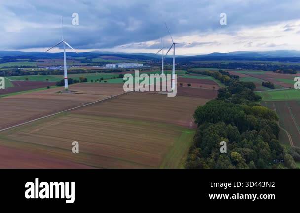 Tall wind turbines generate clean energy, contrasting with the vibrant ...