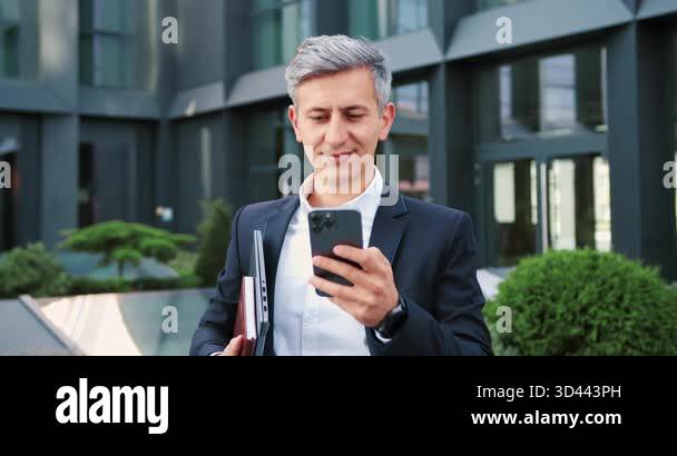Portrait of businessman office employee using smartphone against ...