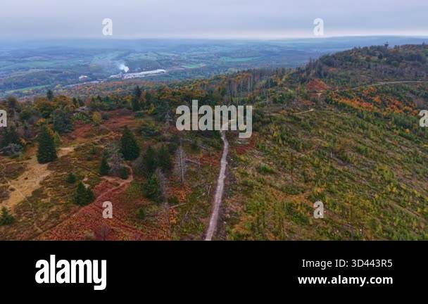 A sweeping landscape reveals vibrant autumn colors across rolling hills ...