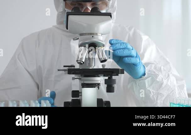 Medical virologist wearing a hazmat suit is working diligently with a ...