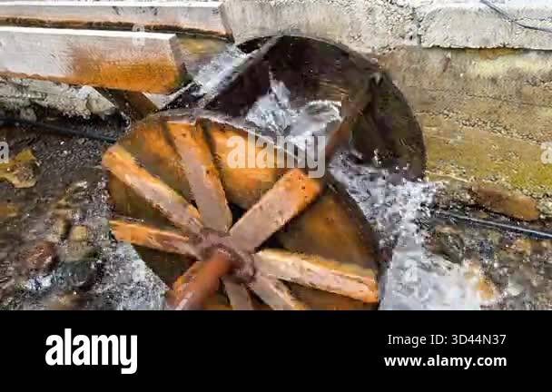 Old world water mill wheel turning with sparkling spray heritage ...