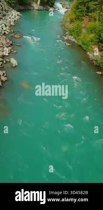 FPV drone flight over the fast moving river with rapids, close to the ...