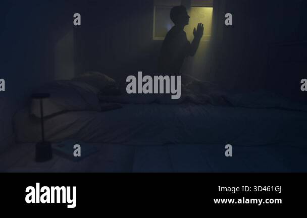 Silhouette of desperate man praying alone at night as divine rays of ...