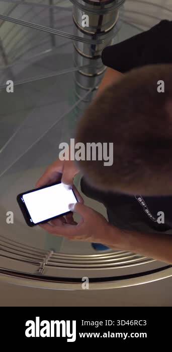 Caucasian man using smartphone and going up stairs at home. Touching ...