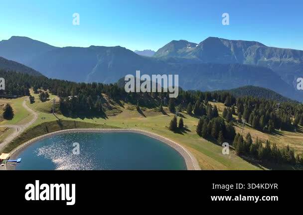 Drone footage showing the green forest slopes and alpine peaks around ...