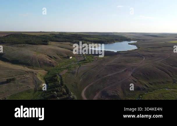 Drone flyover of a tranquil man-made lake and the surrounding farmlands ...