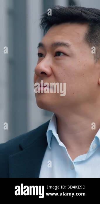 Portrait in city Asian business man looking away pensive smiling toothy ...
