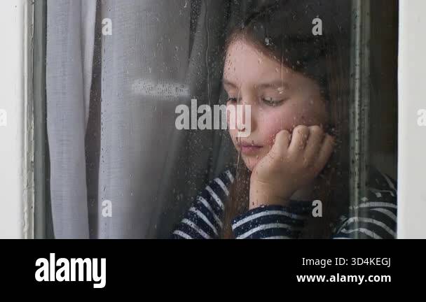 Portrait Caucasian little girl child kid looking out window rainy ...