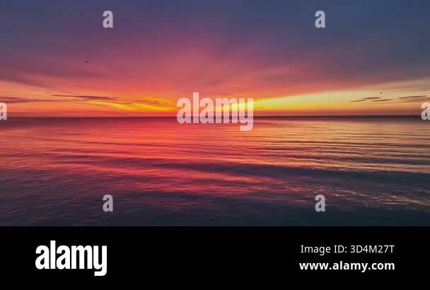 Ocean sunrise with color sky clouds and golden sun rays over island ...