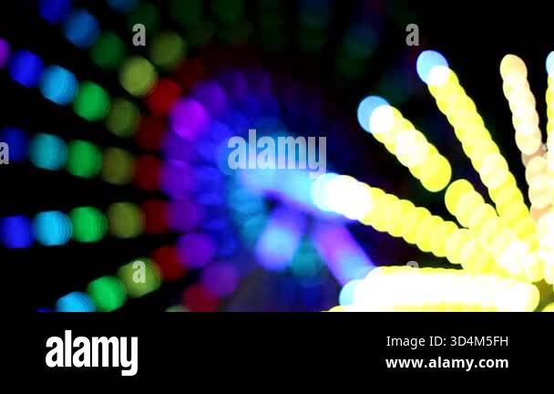 Dynamic, fast-moving rainbow light trails and bokeh spinning against a dark background. Abstract ...