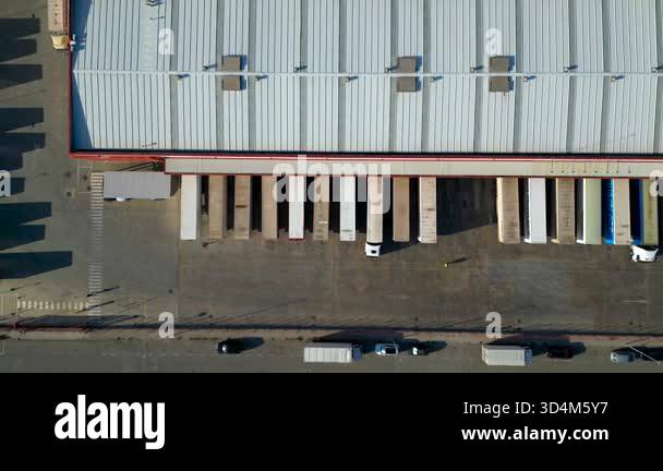 Aerial top-down view of semi-trucks loading and unloading cargo at a ...