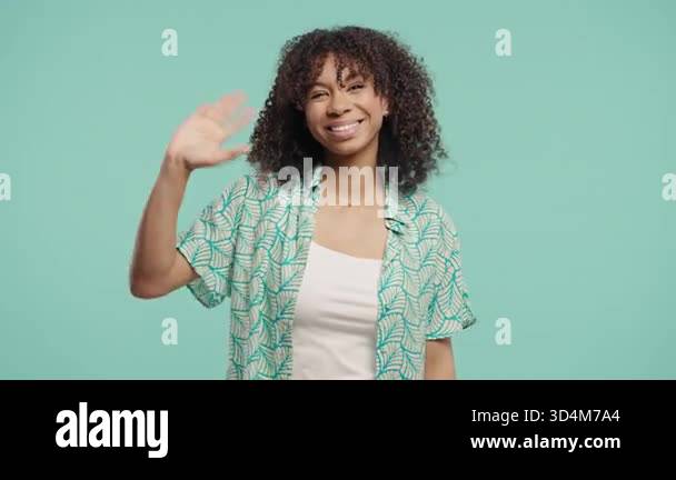 African female model makes clear waving gesture with bright expression ...