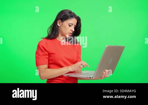 Annoyed woman holding a laptop showing negative emotions against a ...