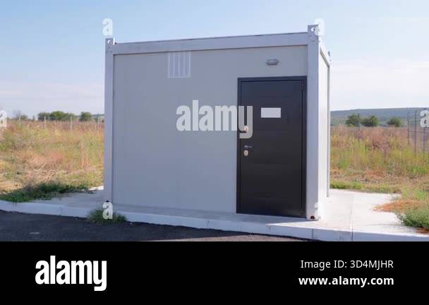 Contemporary utility building features a black door and gray walls ...