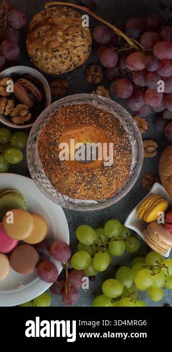 A vertical overhead loop rotates a seeded bagel on a glass plate with ...