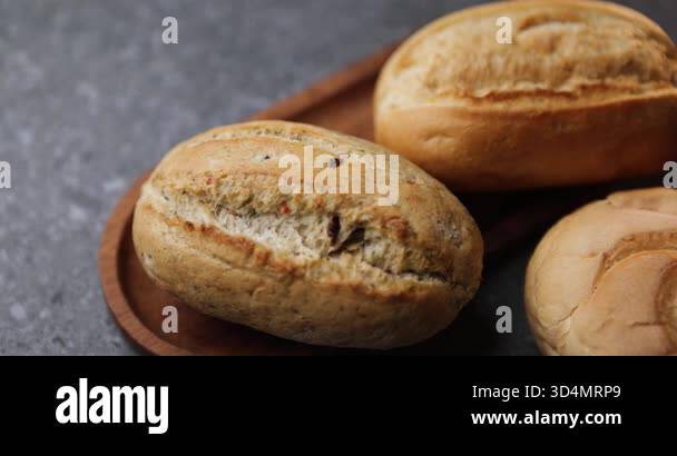 A smooth slider video shows artisan bakery buns resting on a wooden ...